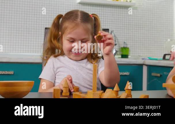 Woman teaching a young girl using toy blocks at home. Early learning ...