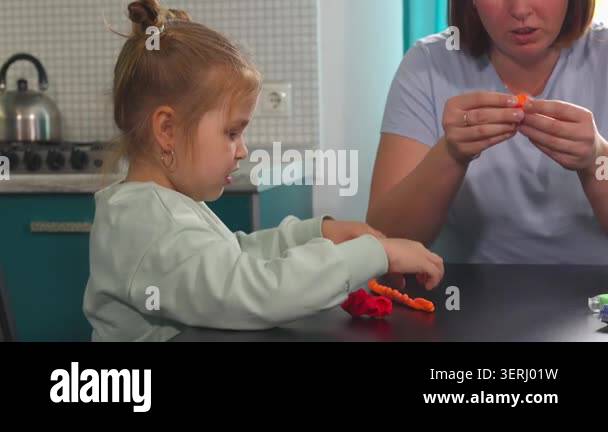 Side view of small Caucasian child is learning to sculpt clay at a ...
