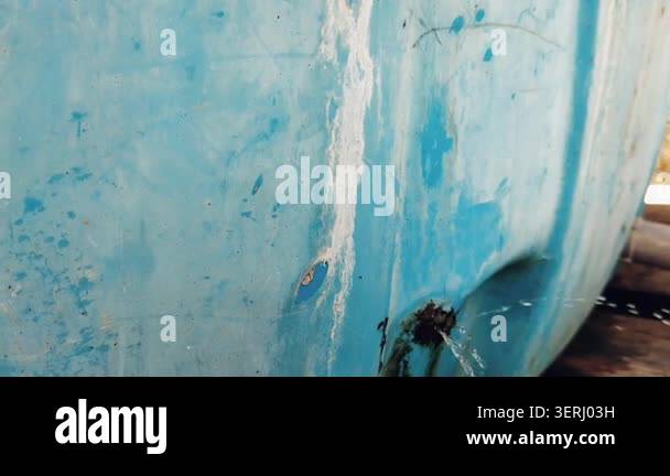Selective focus. Water leakage from crack in water tank installed in ...