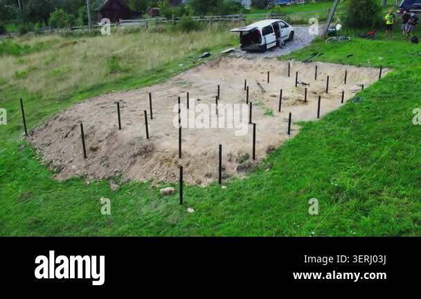 Pile foundation for future wooden frame house on mountain hillside ...
