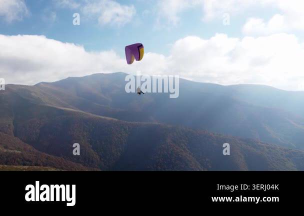 Paragliding active sports with parachute flying against mountains with ...