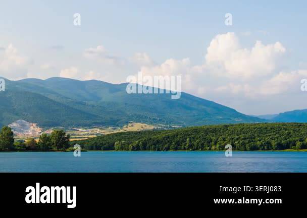 Small blue reflecting lake and clear cool water with stone narrow wild ...