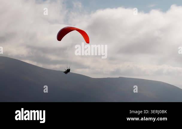 Paragliding active sports with parachute flying against mountains with ...