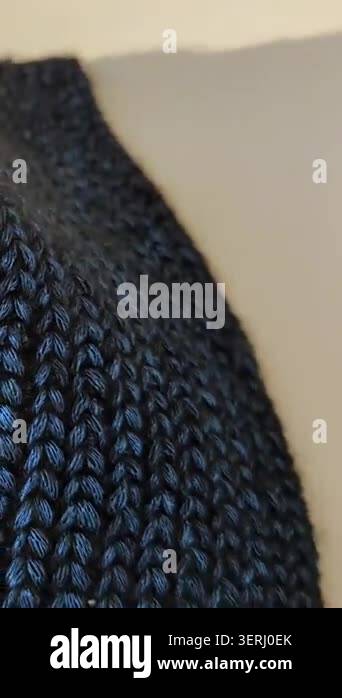 Detailed view of dark blue, textured crocheted fabric on soft beige ...