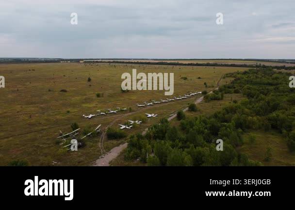 Aerial old abandoned airbase field with weathered hangar, helicopters ...