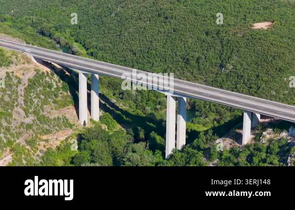 Aerial view of a modern highway bridge crossing mountainous terrain and ...