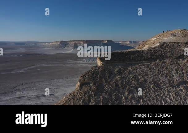 Aerial drone footage flying towards a lone traveler standing on the ...