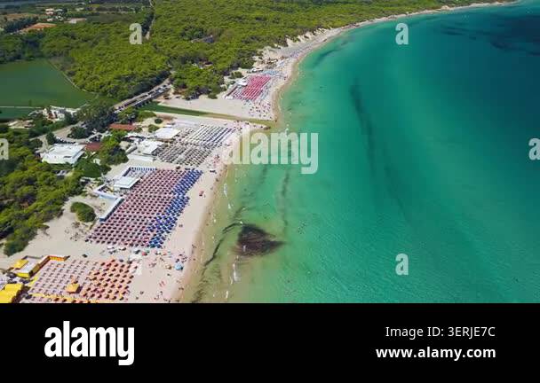 High-angle drone shot of a long white sand beach in Salento during ...