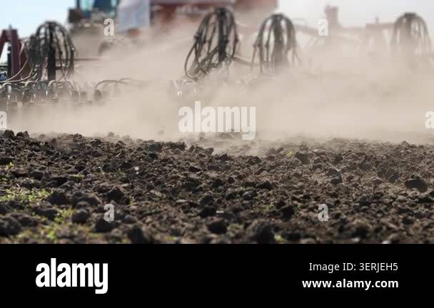 Modern seeding machine operating across cultivated farmland and raising ...