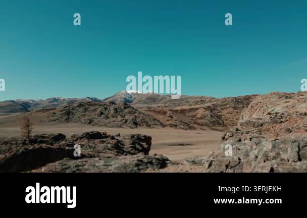 Drone flight over rugged mountain terrain and rocky valley under a ...