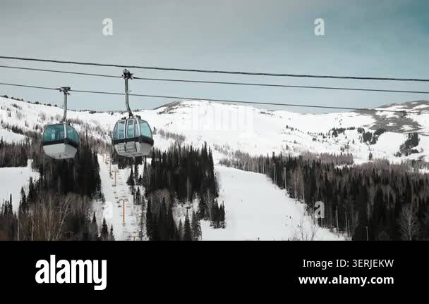 Modern gondola lift operating above snowy mountain slopes. Winter ...