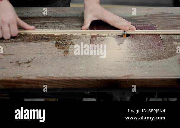 Close up of carpenter shaping wooden trim on router table. Precision ...