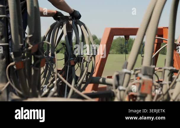 Farmer closing inspection hatch on agricultural seeder after checking ...