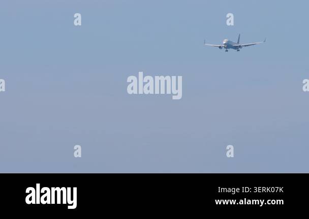 Commercial passenger jet airplane approaching for landing in clear blue ...