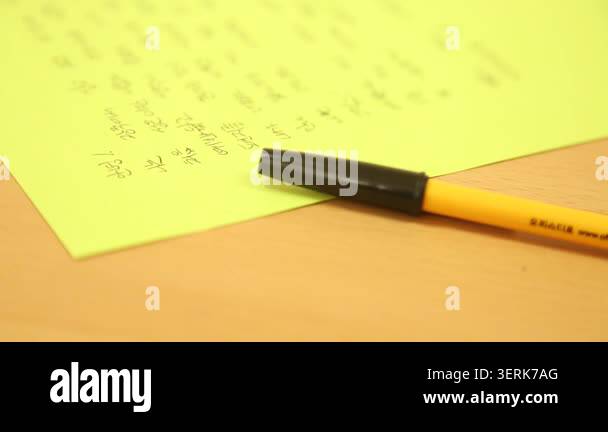 Close up view of Korean handwritten text on yellow paper with a yellow ...