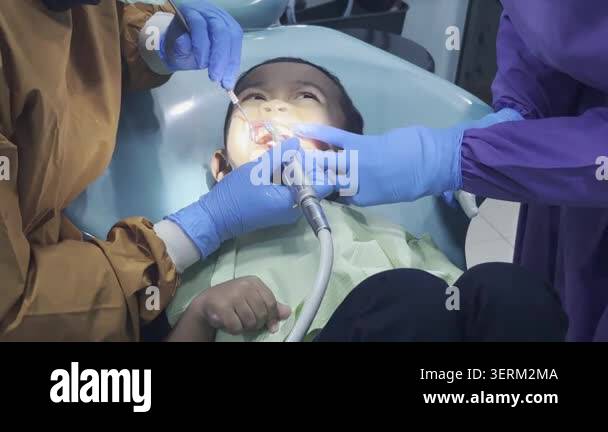 Young boy receiving professional dental cleaning treatment from a ...