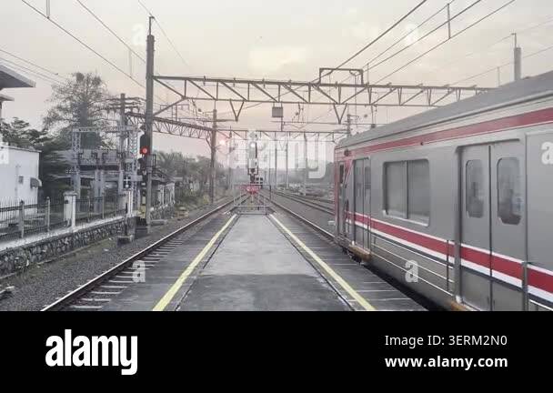Commuter train moving away from a station platform, illustrating public ...