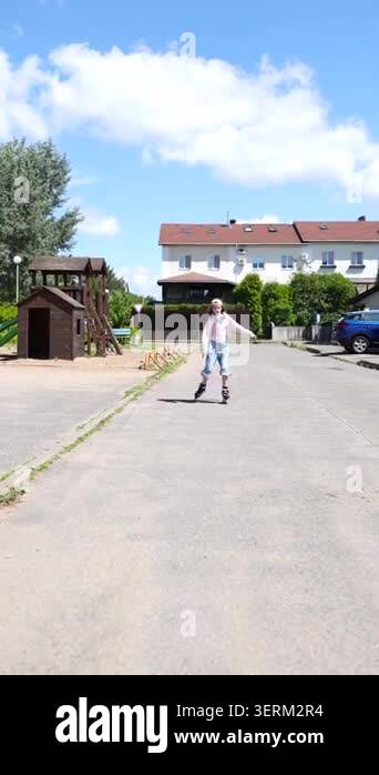 Generation Alpha girl riding inline roller skates on suburban asphalt ...