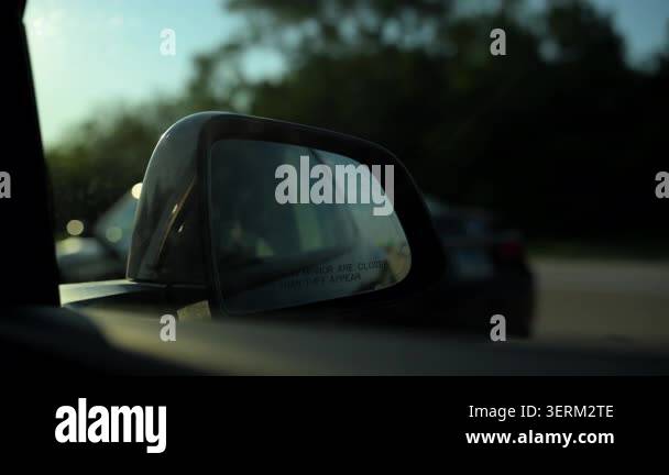Closeup of vehicle side mirror during road travel, reflecting motion ...