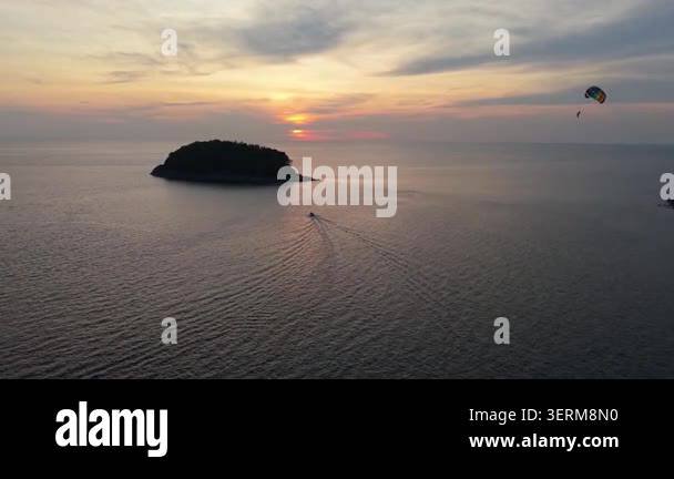 A serene sunset view over the ocean features a small island and a ...