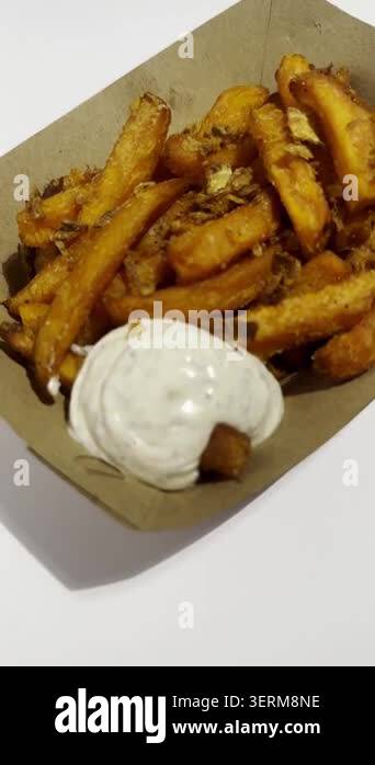Crispy sweet potato fries seasoned with spices and served with a dollop ...