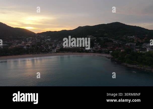 Aerial view of a coastal town during sunset, showcasing the beach ...