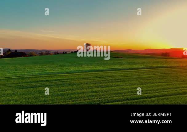 Warm golden light illuminates the landscape while distant hills create ...