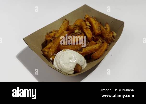 Crispy sweet potato fries seasoned with spices and served with a dollop ...