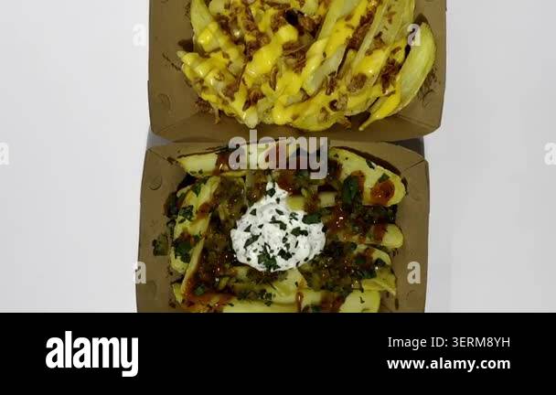 Top down view of various loaded french fries with cheese, bacon, sour ...