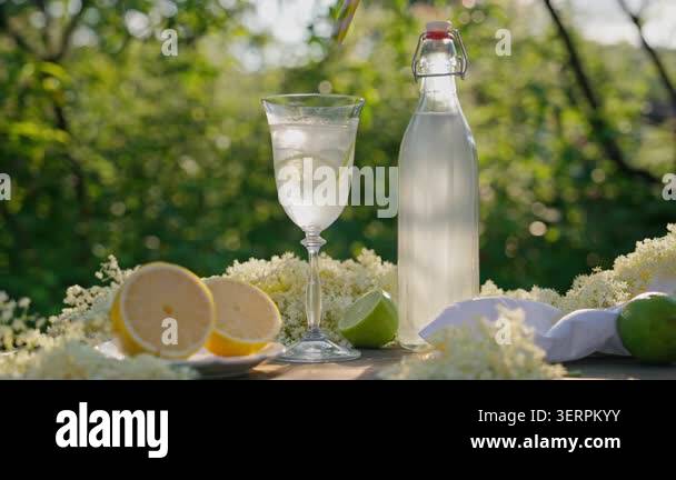 Female hand putting paper straw in a chilled elderflower lemonade ...