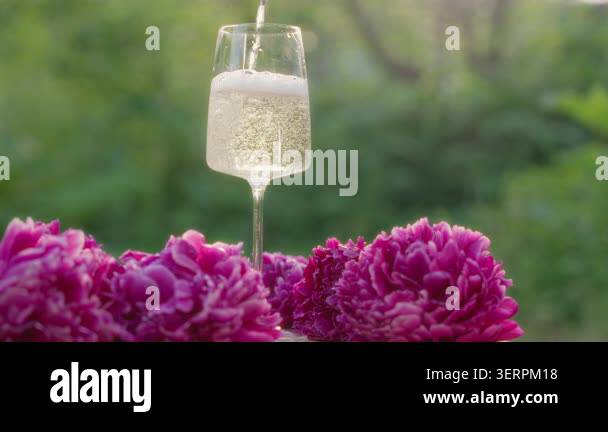 White wine served in a blooming garden surrounded by peonies. Farm-to ...