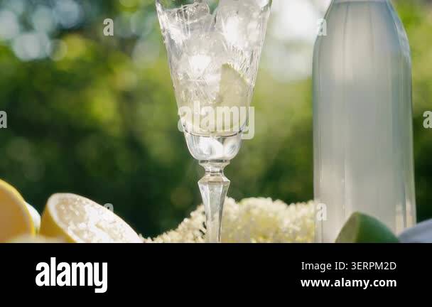Fresh elderflower lemonade poured from glass bottle into elegant ...