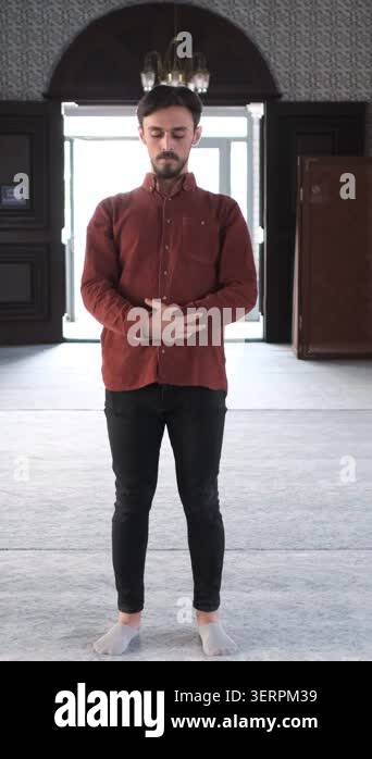 Front view of peaceful man standing to pray in the mosque, men go to ...
