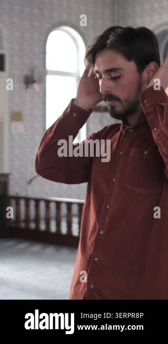 Side view of a bearded Muslim man standing up to pray, the man goes to ...