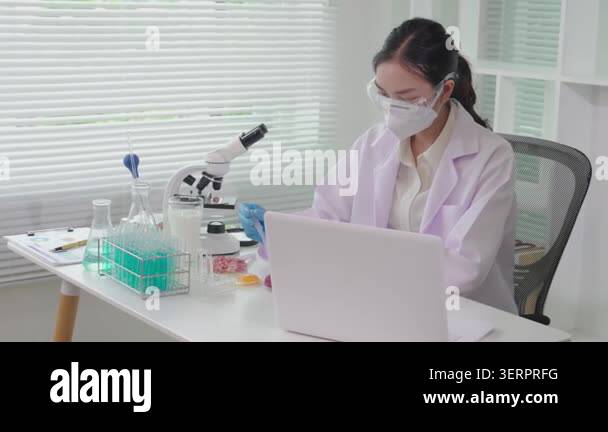 Food scientist using pipette to drop chemical on raw egg yolk in petri ...