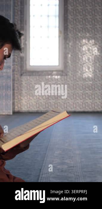 Side view of bearded man sitting in mosque reading Islamic Quran book ...