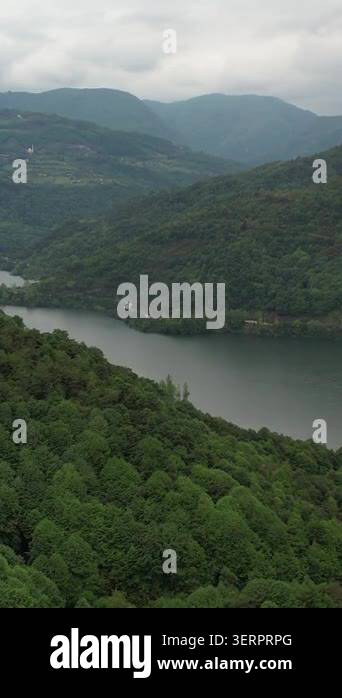 Drone view of lake between two mountains with green forest, the ...
