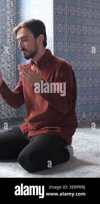 Side view of a young bearded man praying with raised hands people ask ...