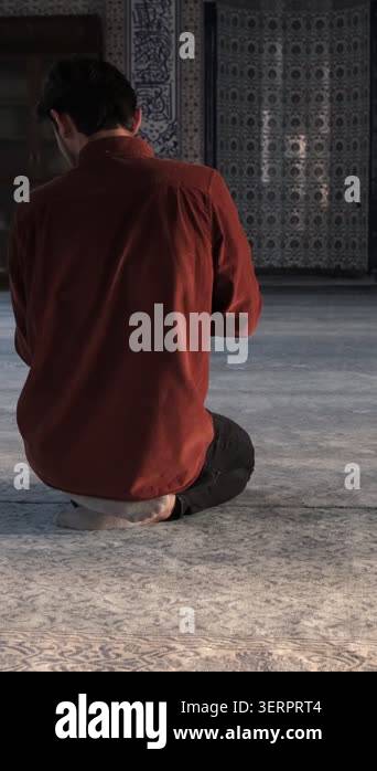 Back view of a bearded man sitting in a mosque reading Islamic Quran ...