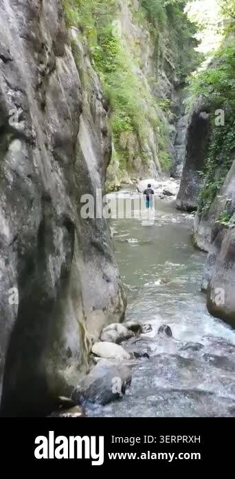A young man walking canyon river aerial view, nature walks among the ...