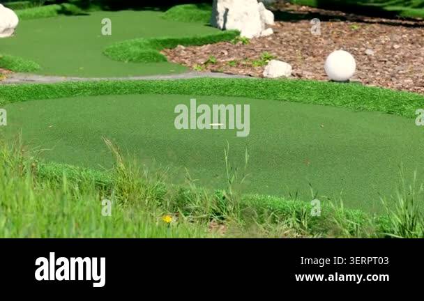 Miniature golf course with green turf and white ball on tee Stock Video ...