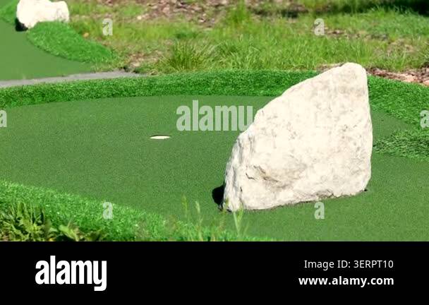 Mini golf course with large stone obstacle on green turf Stock Video ...