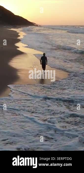 A romantic walk on the beach at sunset flying aerial drone, the ...