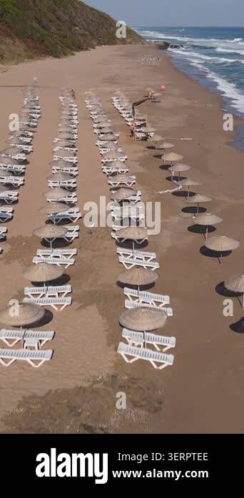 Top-down shot of the beach, showing blue umbrellas in an empty bath ...