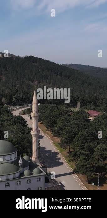 Aerial view of mosque and minaret built on the side of the road in town ...