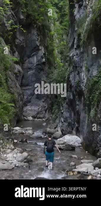 A young man walking canyon river aerial view, nature walks among the ...