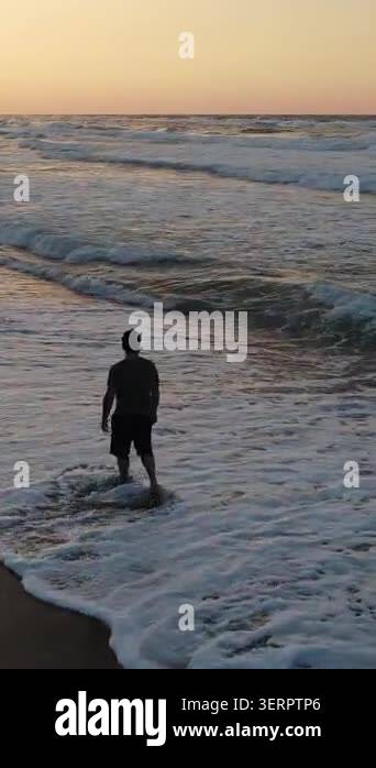 A romantic walk on the beach at sunset flying an aerial drone, the ...