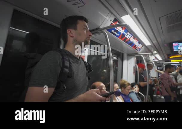 Male passenger on Roman subway in Italy uses smartphone in crowded ...