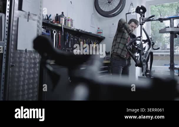 Professional bicycle mechanic servicing a premium road bike in a modern ...