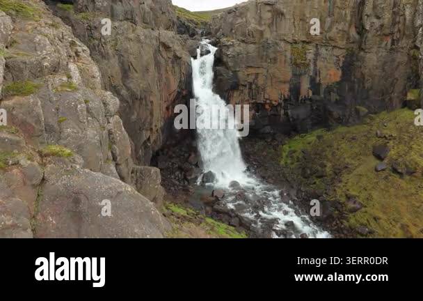 Aerial flight over the wild Fardagafoss waterfall on a summer day in ...